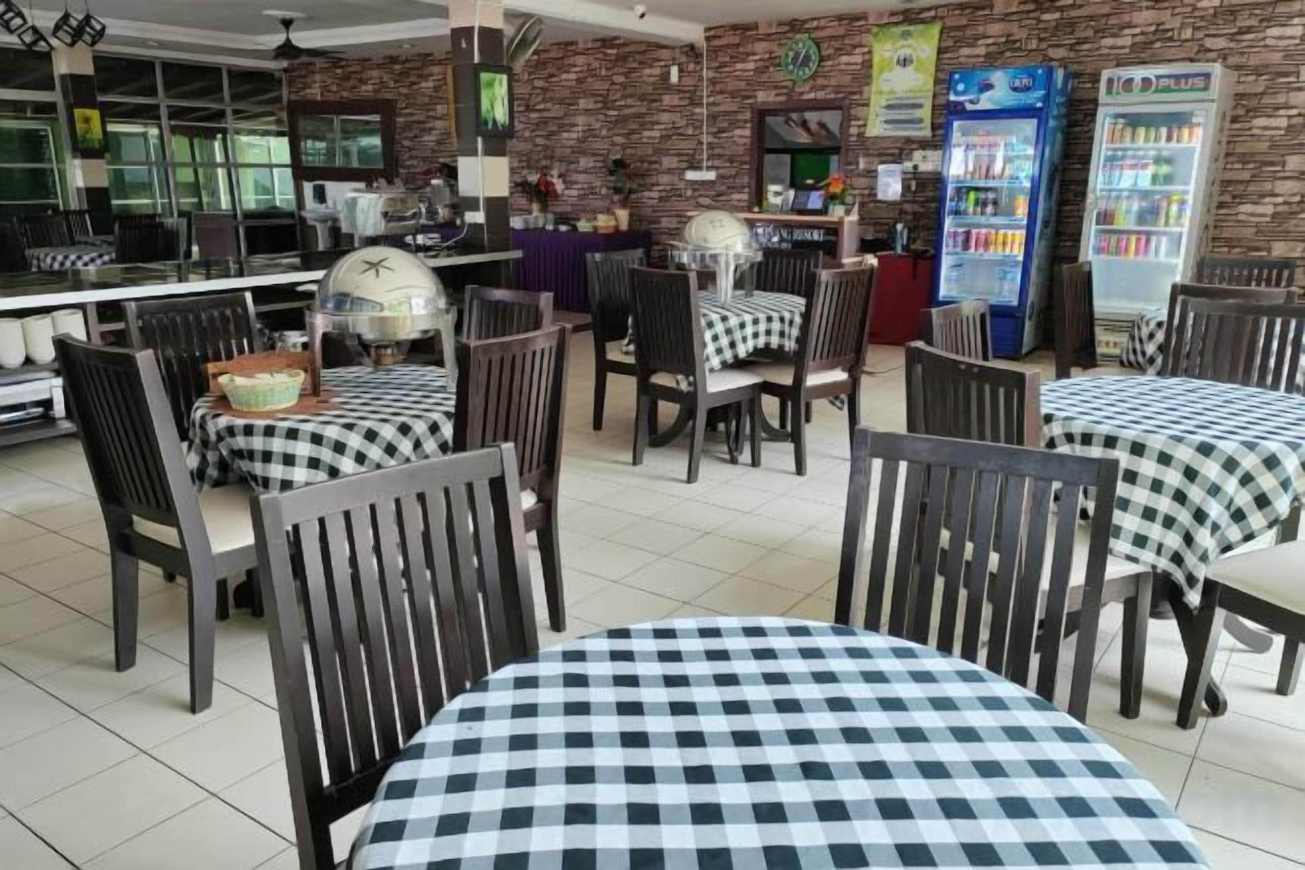Um restaurante com toalhas de mesa xadrez, cadeiras e uma parede de tijolos.