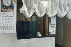 Balcão de recepção com um calendário, um relógio e um telefone.