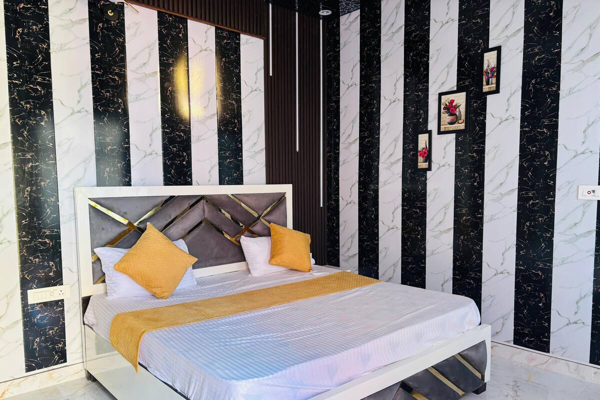 Um quarto moderno com uma cama, cabeceira e parede com listras verticais.