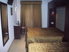 Quarto de hotel com cama, escrivaninha e cadeira.