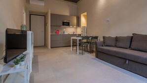 Um espaço compacto com cozinha compacta, área de refeições e sofá.