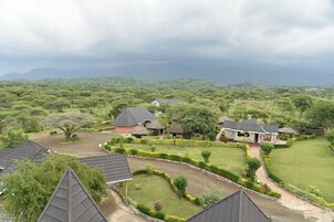 Um bairro residencial com várias casas, cercado por vegetação exuberante e uma paisagem acidentada.