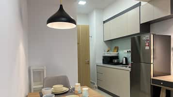 Suíte estúdio família, sacada, vista para a cidade | Cozinha privada | Geladeira, micro-ondas, fogão, mesas de jantar