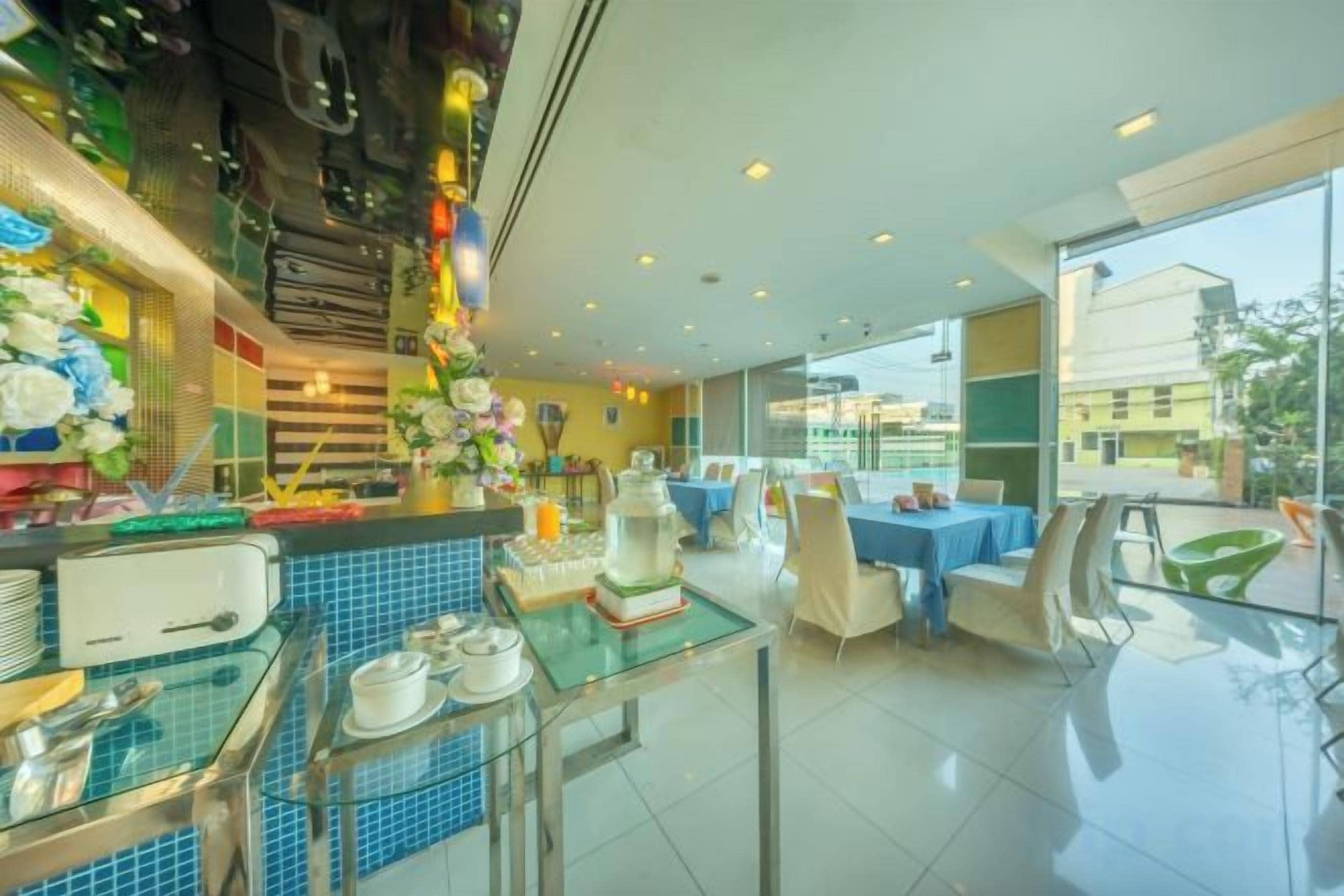 Um restaurante moderno com área de bar, mesas de jantar e vista para o exterior.