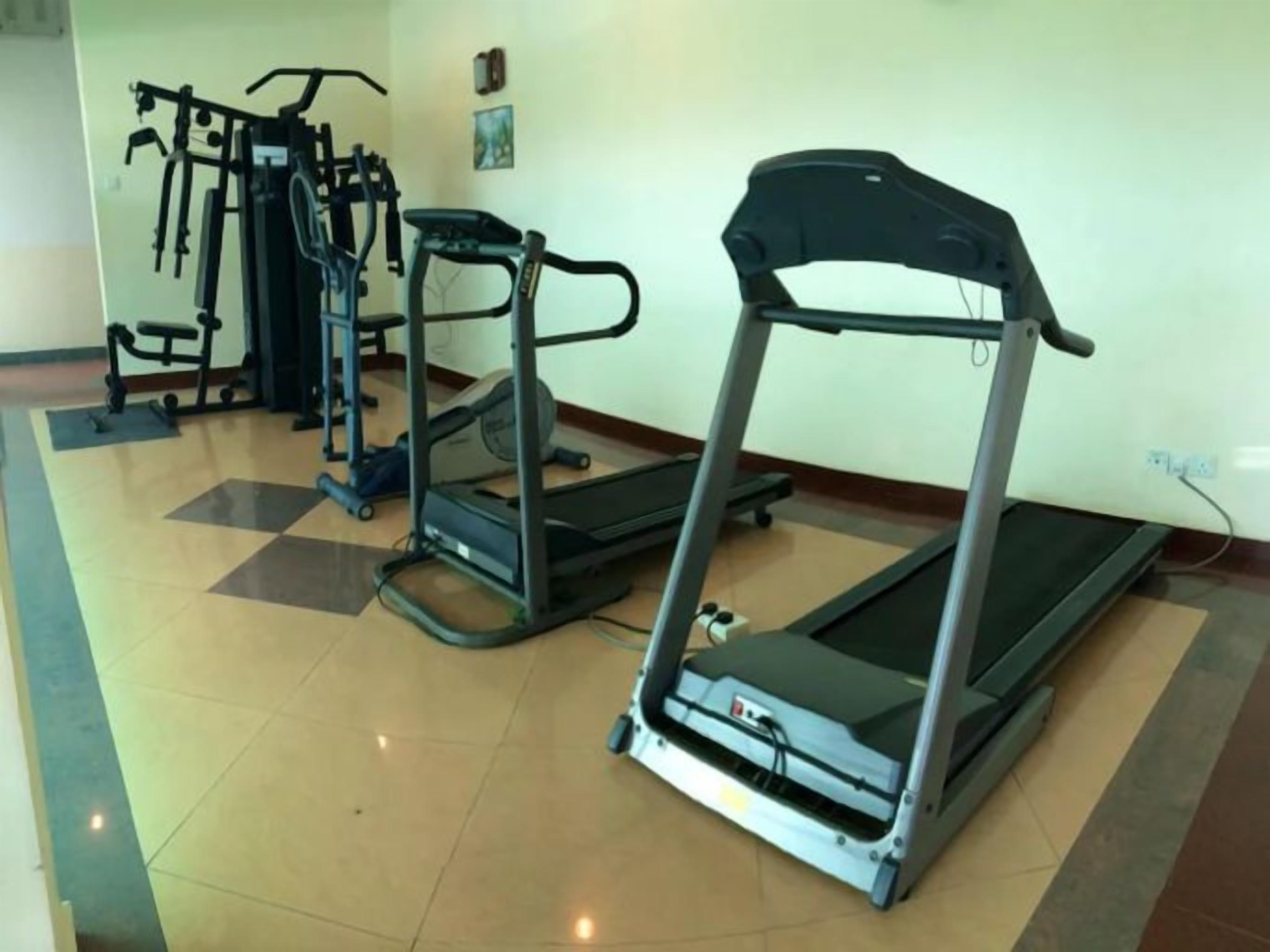 Academia com esteiras, aparelhos de musculação e equipamentos de ginástica.