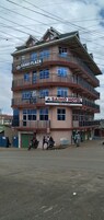 Um edifício com vários andares e uma placa com a inscrição "SAIMO HOTEL" no andar térreo.