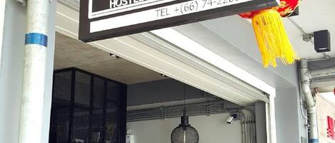Placa com a inscrição 'ROOM 2U HOTEL & GUEST HOUSE' e um número de contato.