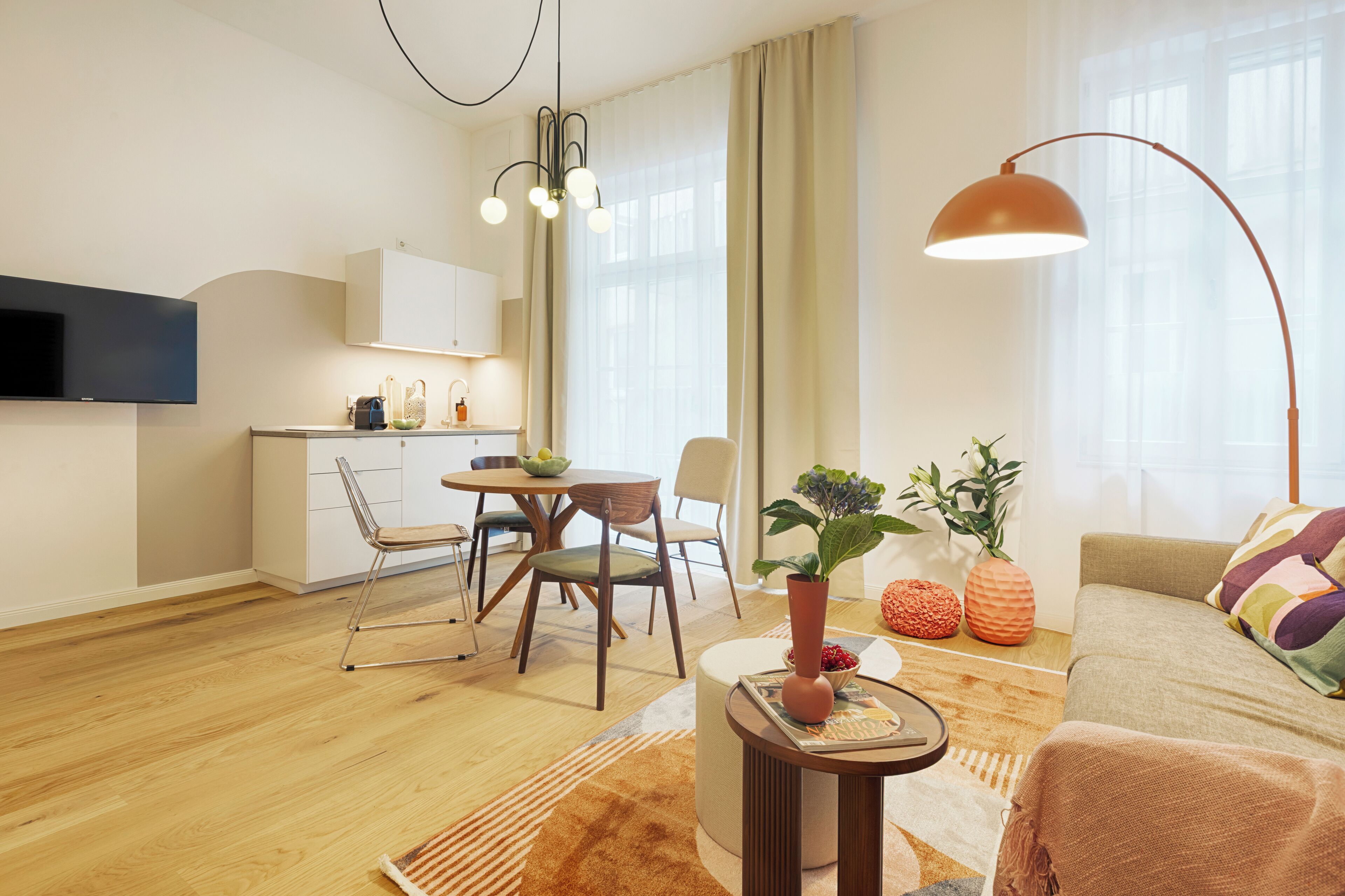 Uma sala de estar moderna com um sofá, uma mesa de centro e um espaço de jantar com cadeiras e uma mesa.