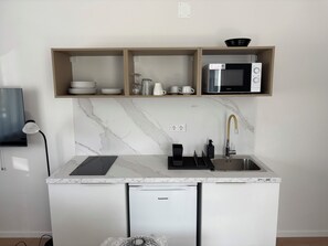 Um frigorífico, um micro-ondas, uma placa de cozinha, uma torradeira 