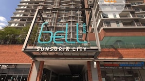 Um edifício de vários andares com um letreiro de destaque que diz 'Bell Suites'.