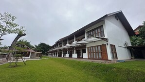 Um edifício moderno de dois andares com telhado plano e janelas amplas.