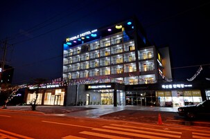 Um hotel de vários andares com uma placa chamativa que diz "Noble Hotel Yeosu".