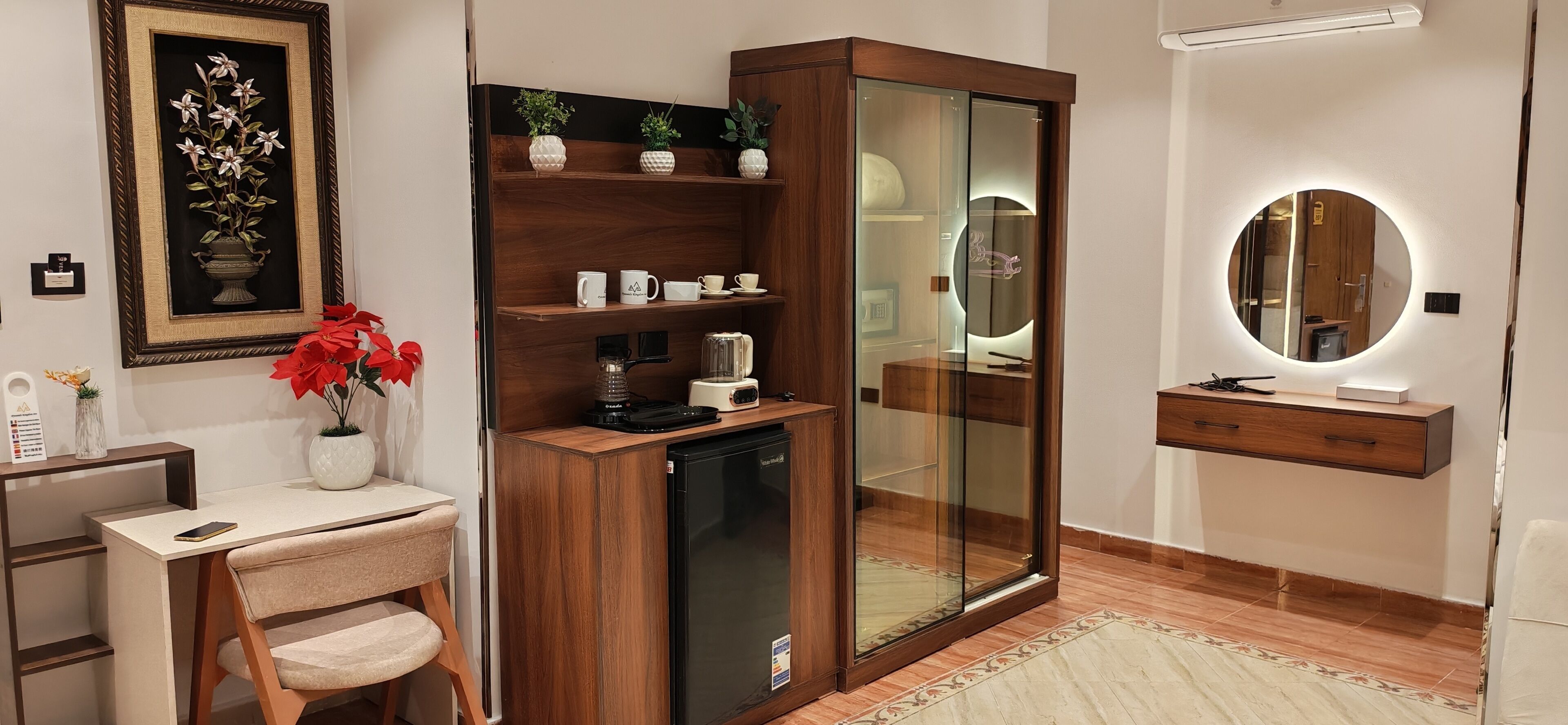 Uma casa de banho moderna com chuveiro em cabine de vidro, toucador com espelho e secretária com cadeira.