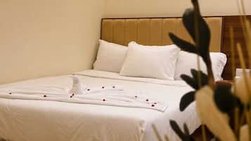 Quarto de hotel com cama, cabeceira de madeira e tapete marrom.