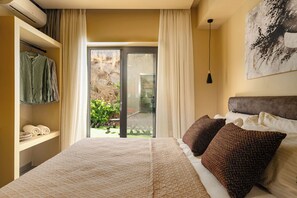 Quarto de hotel com cama, guarda-roupa, janela com cortinas e um quadro na parede.