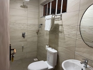 Chuveiro, chinelos, toalhas de banho, sabonete