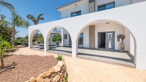 Um edifício moderno com paredes brancas, entradas em arco e fachada de pedra.