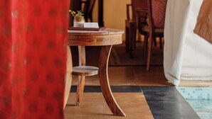 Um quarto acolhedor com uma mesa de madeira, cadeiras e uma pequena planta.