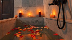Uma banheira com velas e pétalas de rosa.
