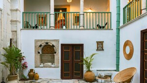 Um edifício tradicional com varanda, porta e janela com arco decorativo.