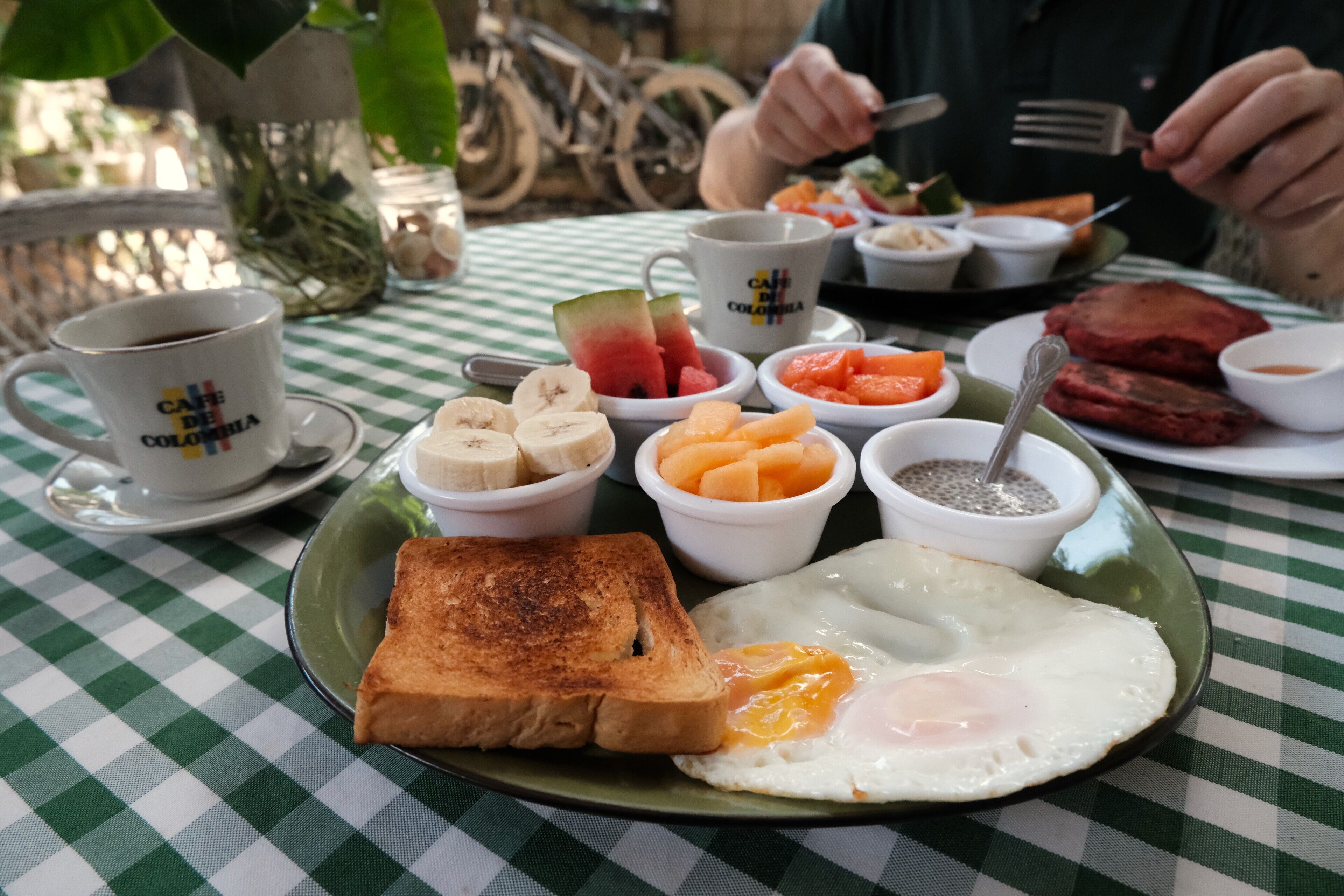 Prato de café da manhã com torradas, ovo, fruta e uma xícara de café.