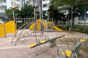 Um parquinho com diversos equipamentos, incluindo balanços e estruturas de escalada.
