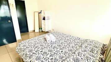 Quarto de hotel com uma cama, um guarda-roupa e uma porta.