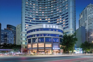 Um hotel moderno com fachada curva, vários andares e entrada imponente.