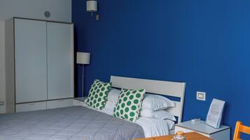 Um quarto com uma cama, uma mesa de madeira e cadeiras.