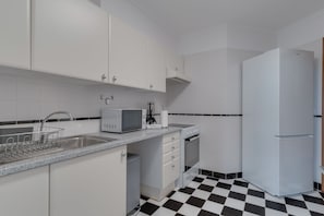 Apartamento família, sacada, vista para a cidade | Cozinha privada