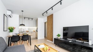 Uma sala de estar moderna com um sofá, mesa de centro e televisão de tela plana.
