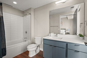 Uma casa de banho moderna com banheira, sanita e lavatório.