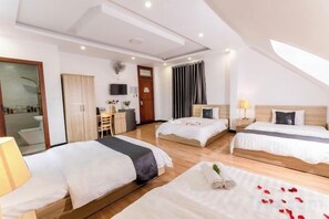 Quarto de hotel com duas camas, uma mesa, uma cadeira e um chuveiro.