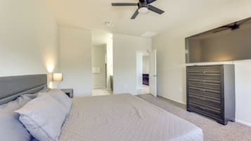 Quarto com cama, ventoinha no teto, cômoda e closet espaçoso.