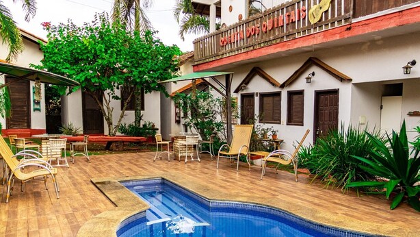 Piscina com espreguiçadeiras e área de estar ao ar livre.