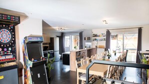 Cozinha moderna com dardos, mesa de futebol de mesa e área de jantar com vista.