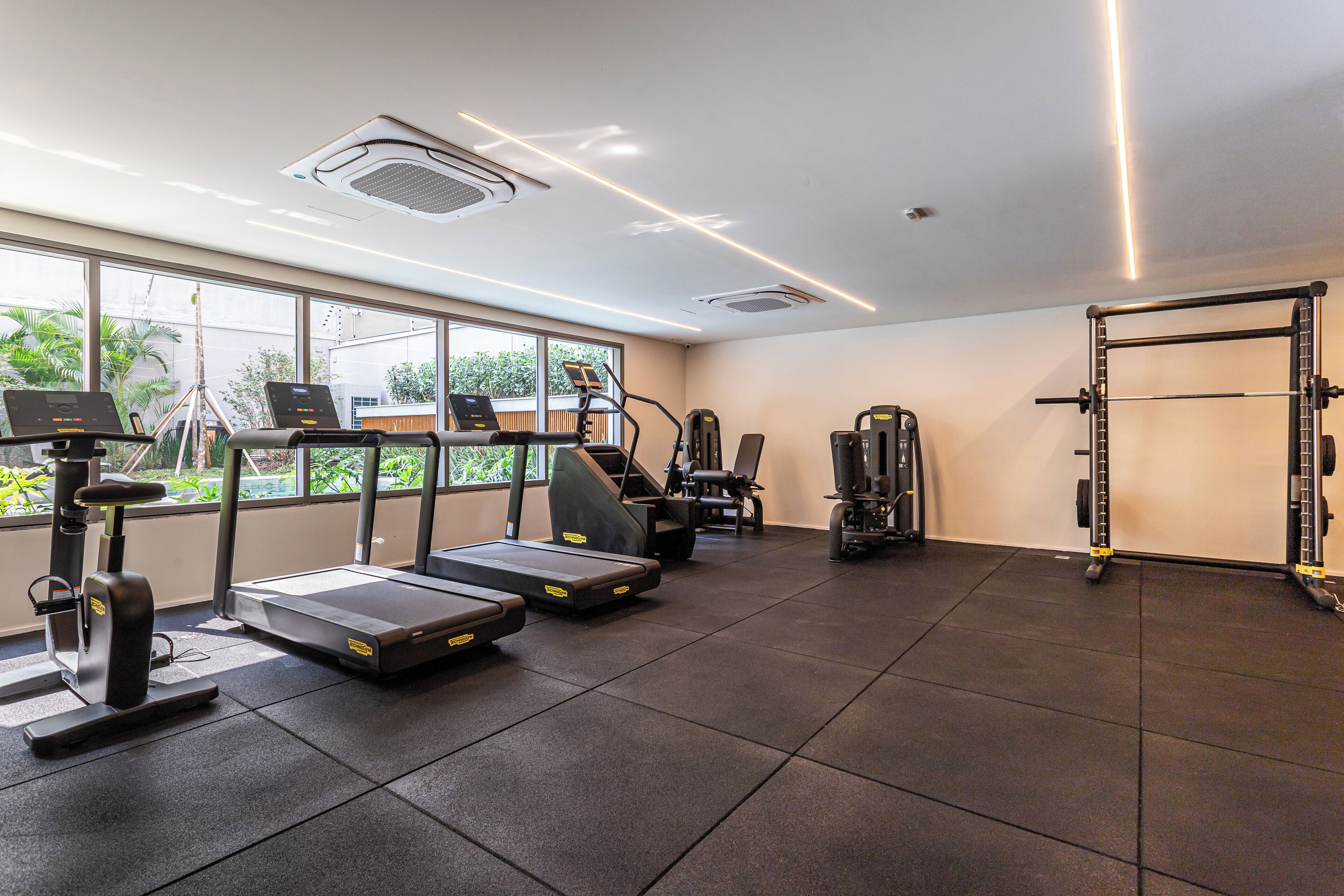Uma academia moderna com esteiras, remo e equipamentos de musculação.