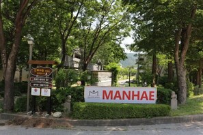 Placa do hotel Manhae, com vista clara para o verde ao redor e uma estrada.