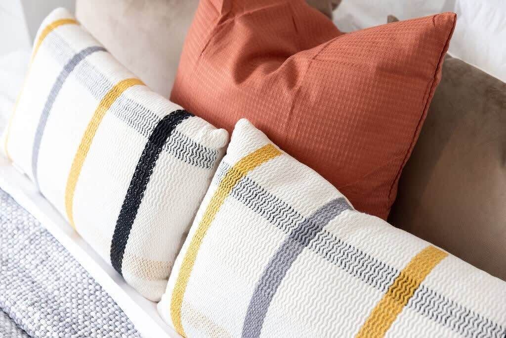 Parte de uma cama com almofadas e um cobertor.