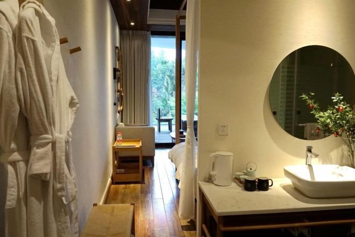 Casa de banho com lavatório, espelho e porta-toalhas.