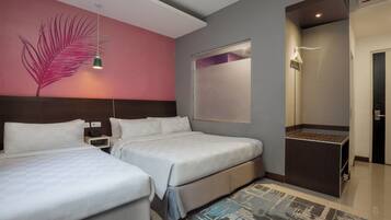 Quarto de hotel com duas camas, um espelho grande, mesa de cabeceira, luminária acoplada à parede e pequena prateleira de madeira.