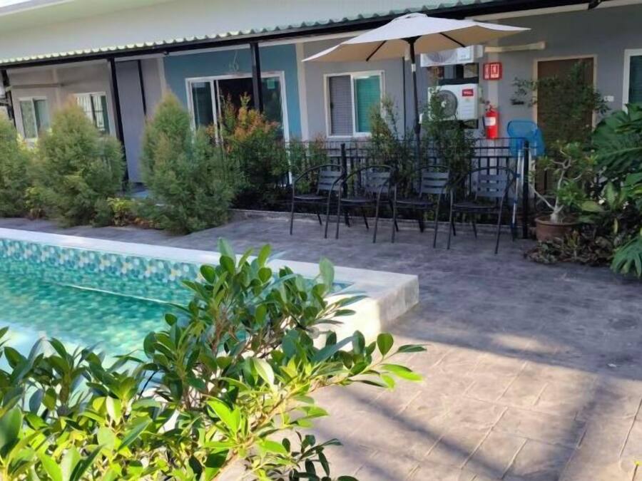 Área de piscina com um pátio, assentos externos e um extintor de incêndio.