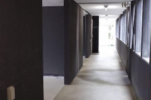 Um corredor com portas em ambos os lados, dando acesso a quartos.