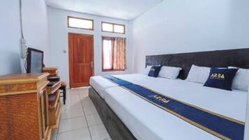 Quarto de hotel com uma cama, uma escrivaninha e uma porta.