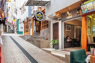 Uma rua estreita com um restaurante chamado "INKARY MACHUPICCHU" e uma placa indicando comida "MEXICANA".