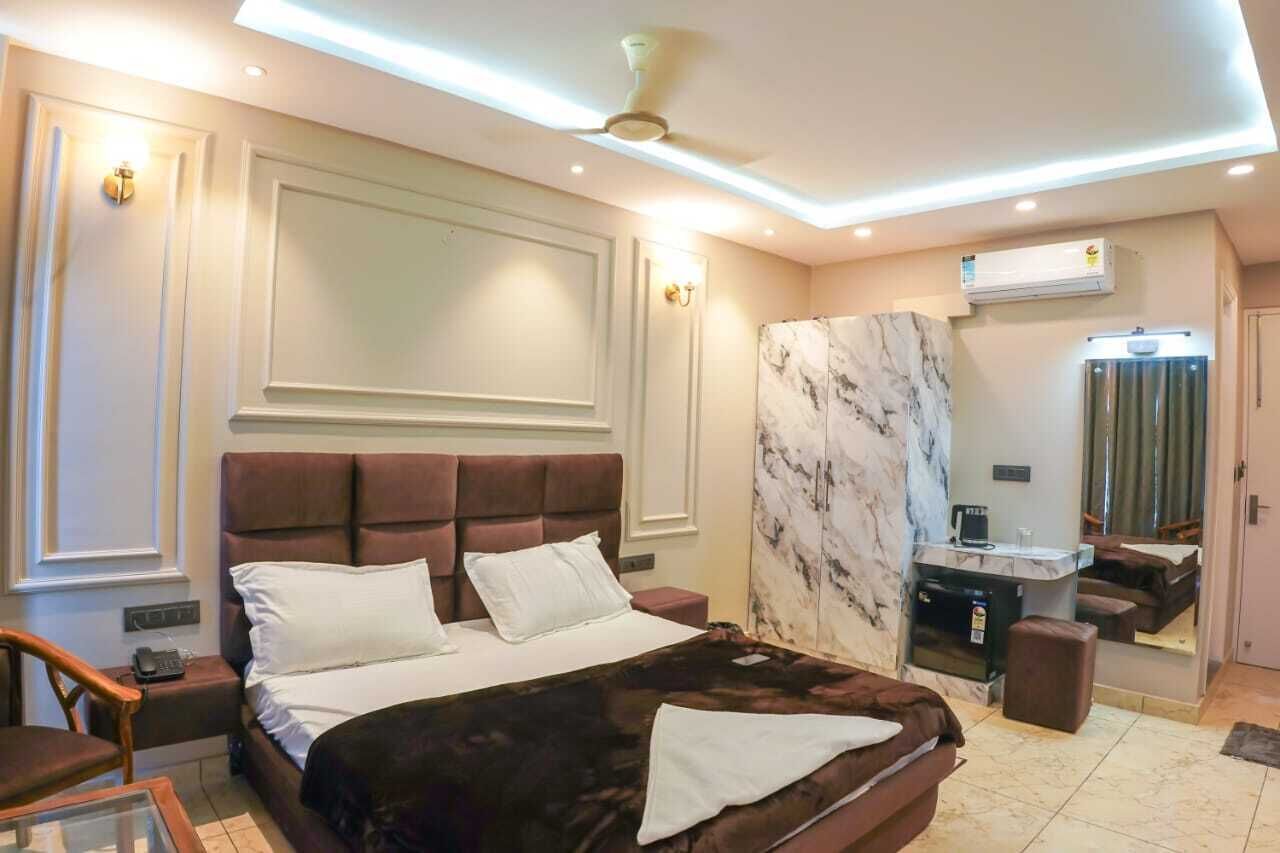 Quarto com uma cama grande, parede decorada em mármore, penteadeira com espelho e ventoinha de teto.