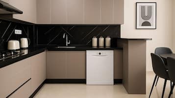 Uma cozinha moderna com máquina de lavar louça, bancada preta e design minimalista.