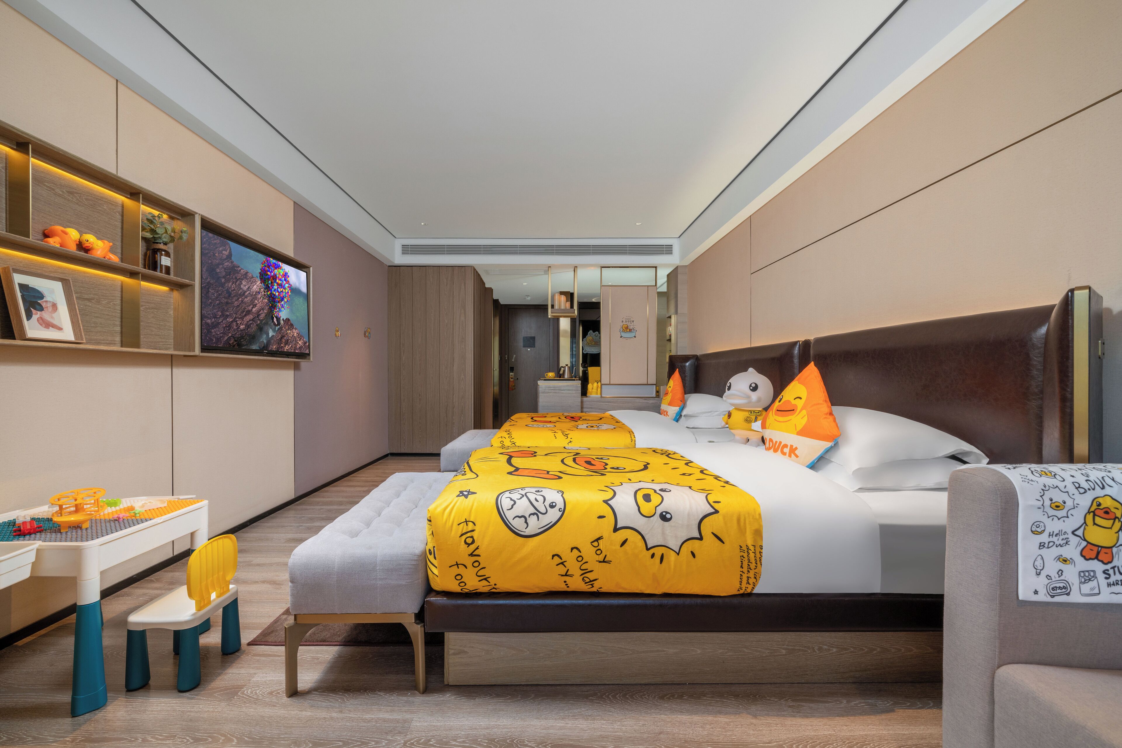 Quarto de hotel moderno com uma cama grande, uma escrivaninha e um espaço de estar.