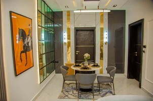 Uma zona de refeições moderna com uma mesa redonda, quatro cadeiras e um vaso de flores.