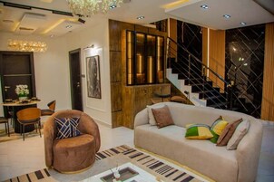 Uma sala de estar moderna com sofá, poltrona e escada.